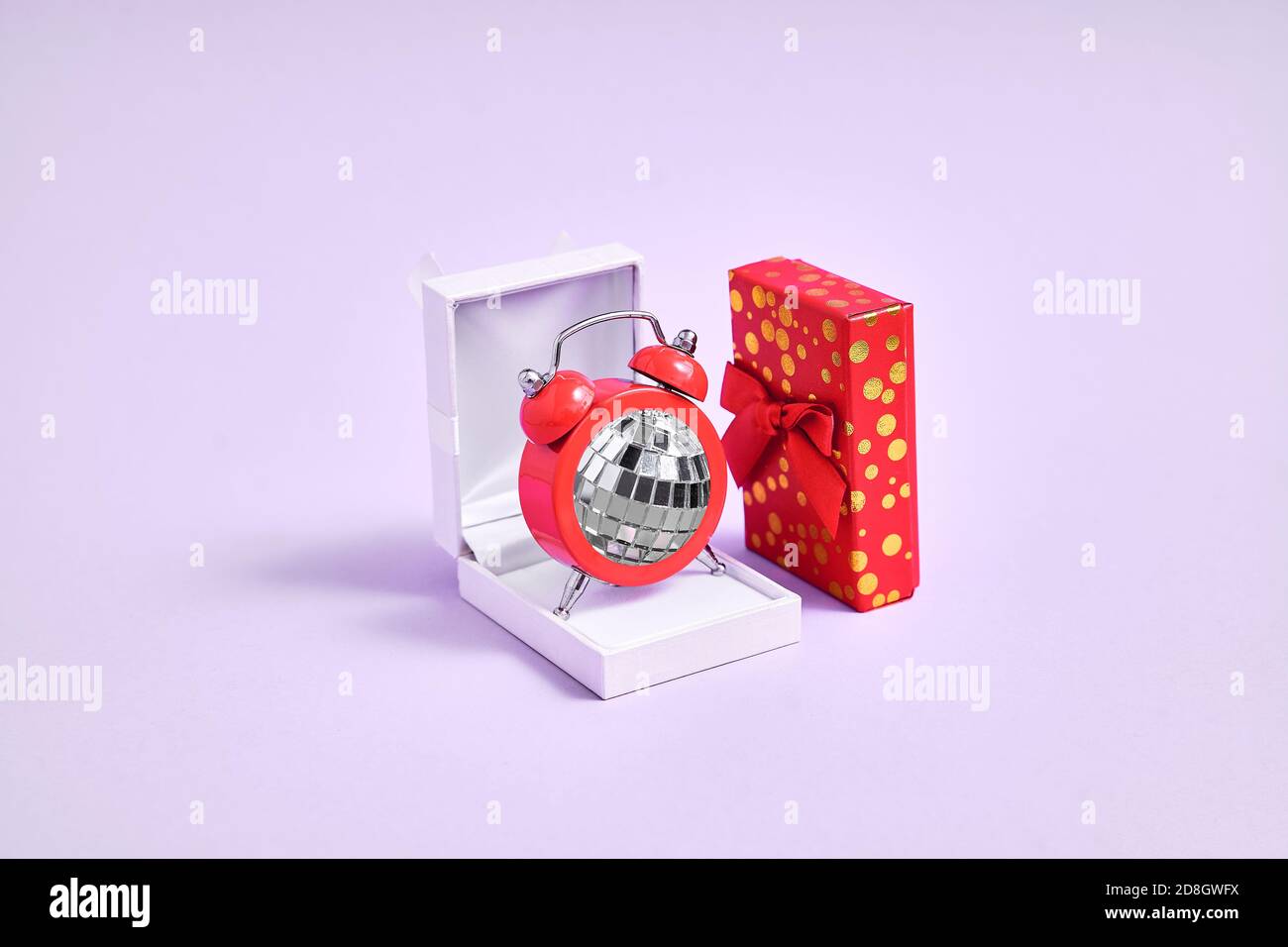 Red alarm clock with disco ball in it. christmas time Stock Photo - Alamy