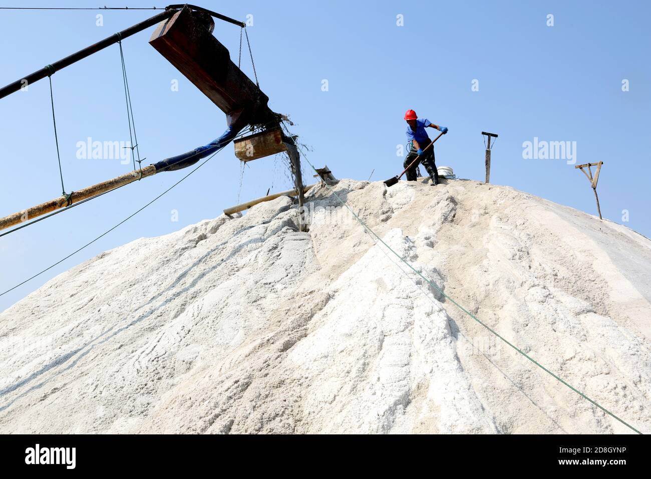 Aerial view of workers carrying salt in a salt field in Lianyungang ...