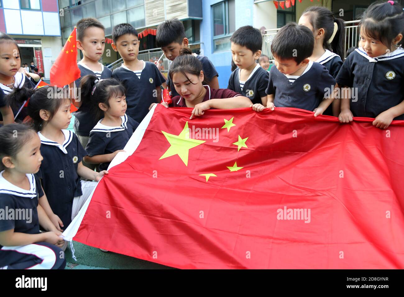 Kids hold a Chinese flag used in a class as patriotic education at the ...