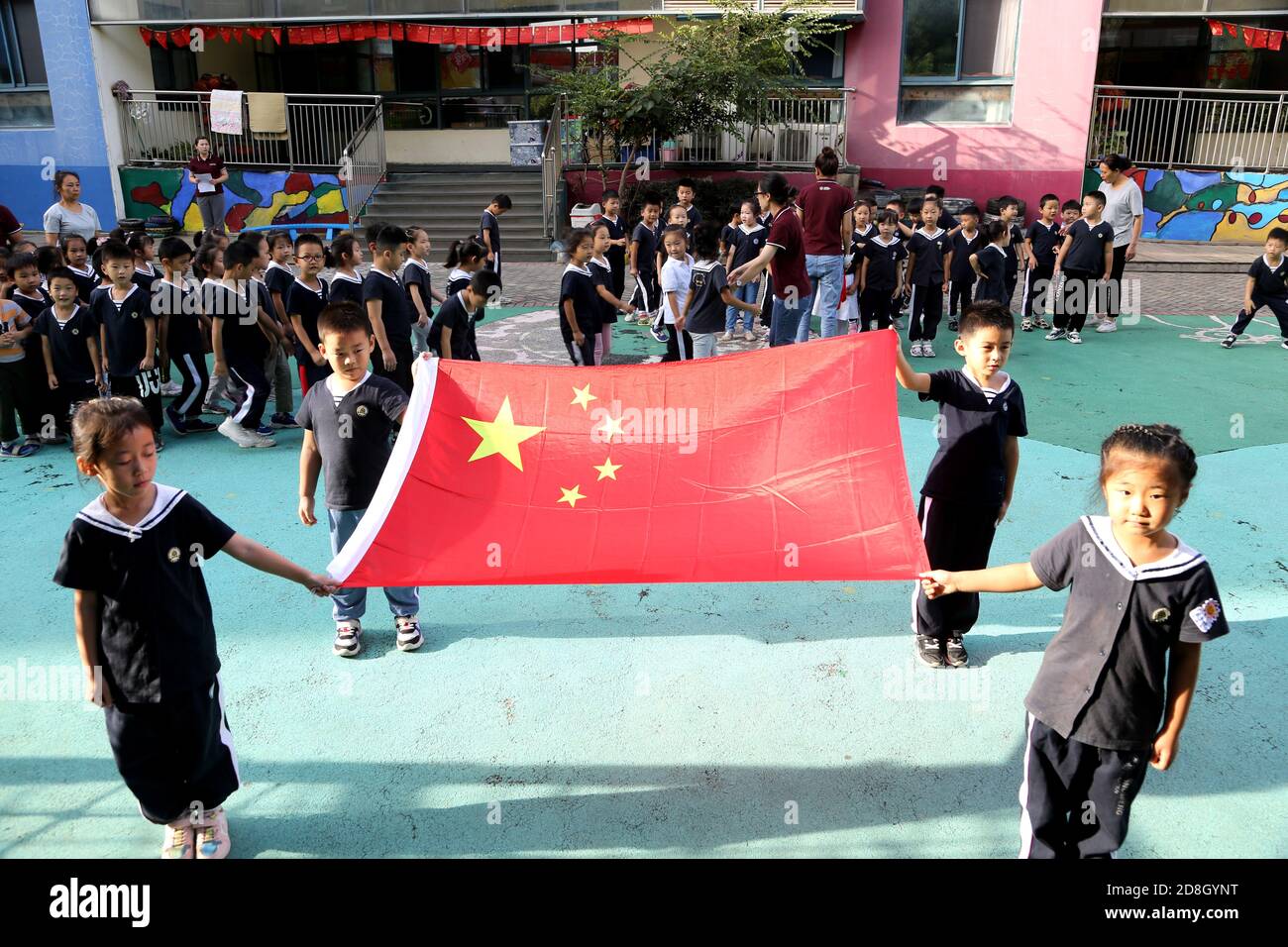Kids hold a Chinese flag used in a class as patriotic education at the ...
