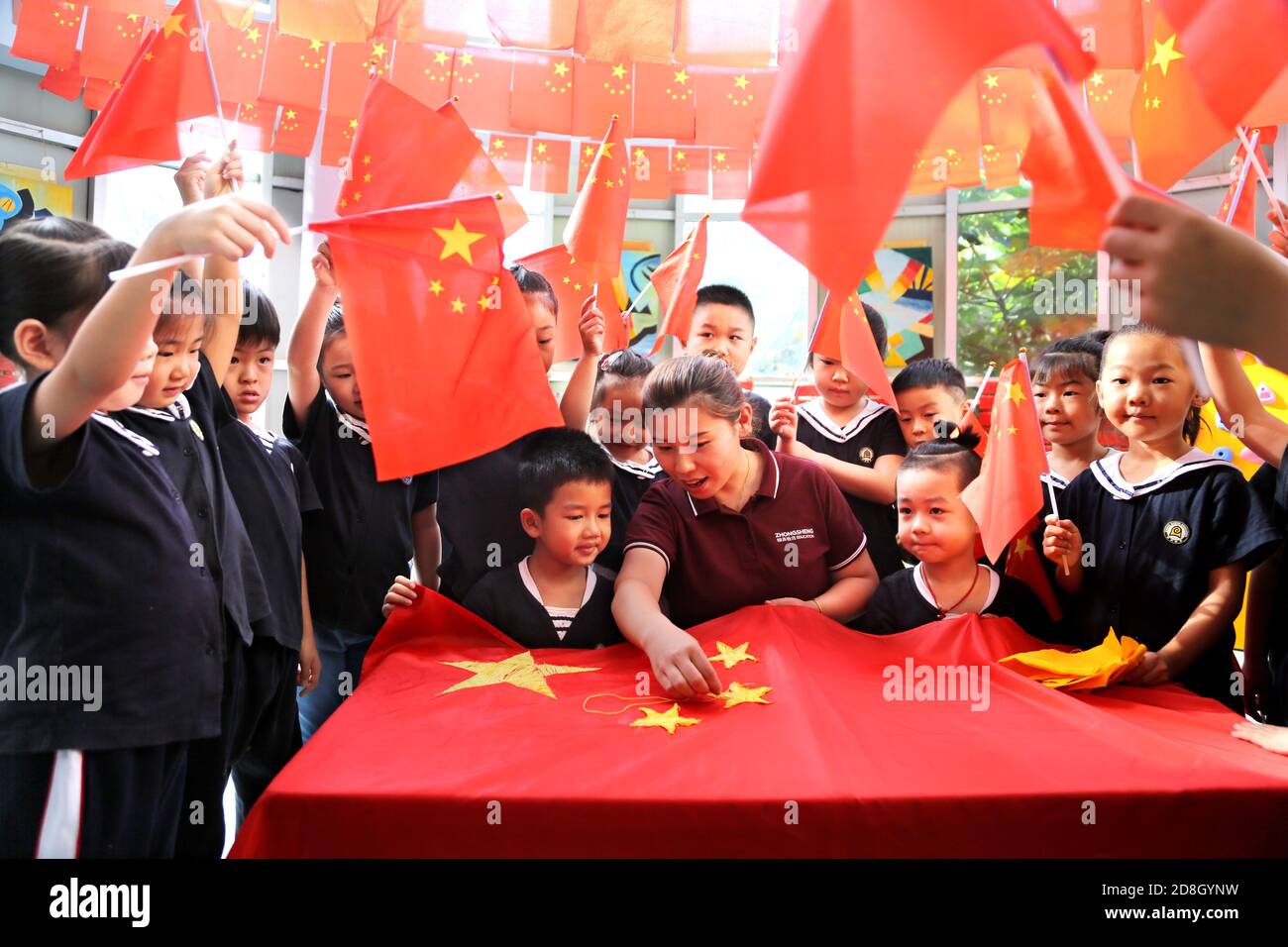 Kids hold a Chinese flag used in a class as patriotic education at the ...