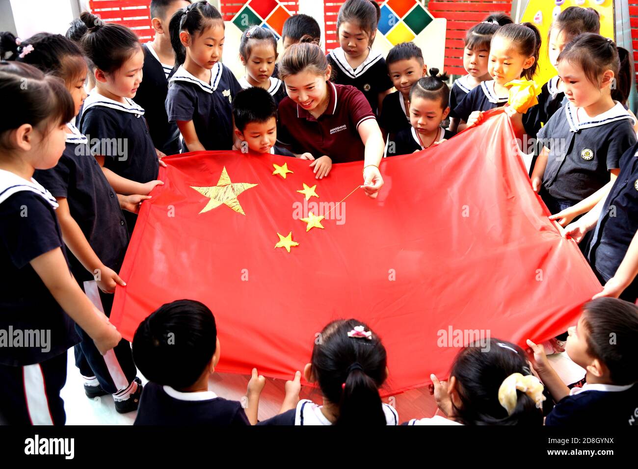 Kids hold a Chinese flag used in a class as patriotic education at the ...