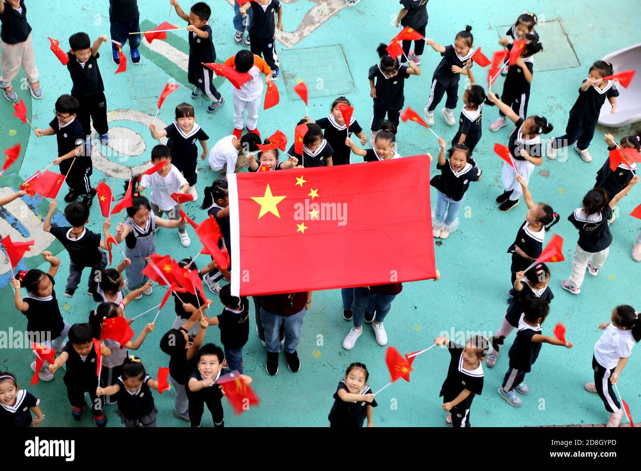 Kids hold a Chinese flag used in a class as patriotic education at the ...
