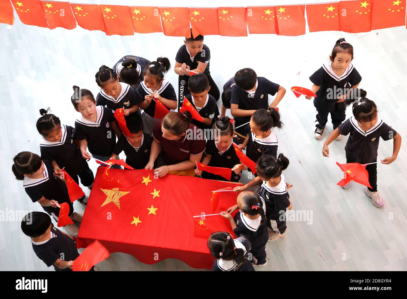 Kids hold a Chinese flag used in a class as patriotic education at the ...