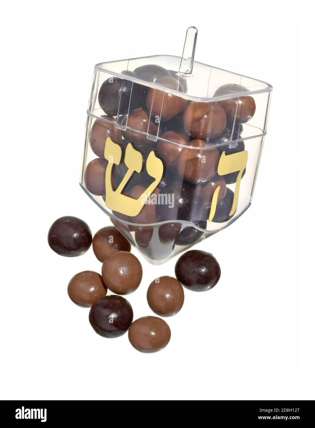 dreidel toy filled with chocolates photographed on a white background ...