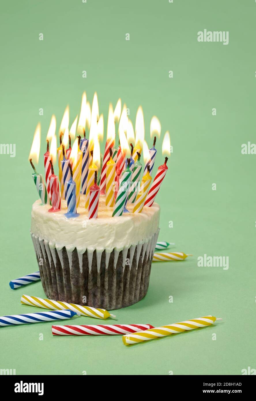 Cupcake with many lit candles photographed on a green background Stock ...