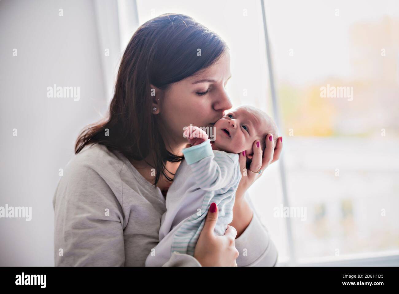 newborn baby in a tender embrace of mother at window Stock Photo - Alamy