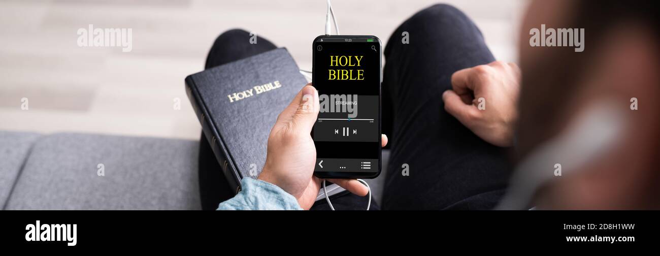 Christian Man Reading Bible Book On Phone And Praying Stock Photo - Alamy