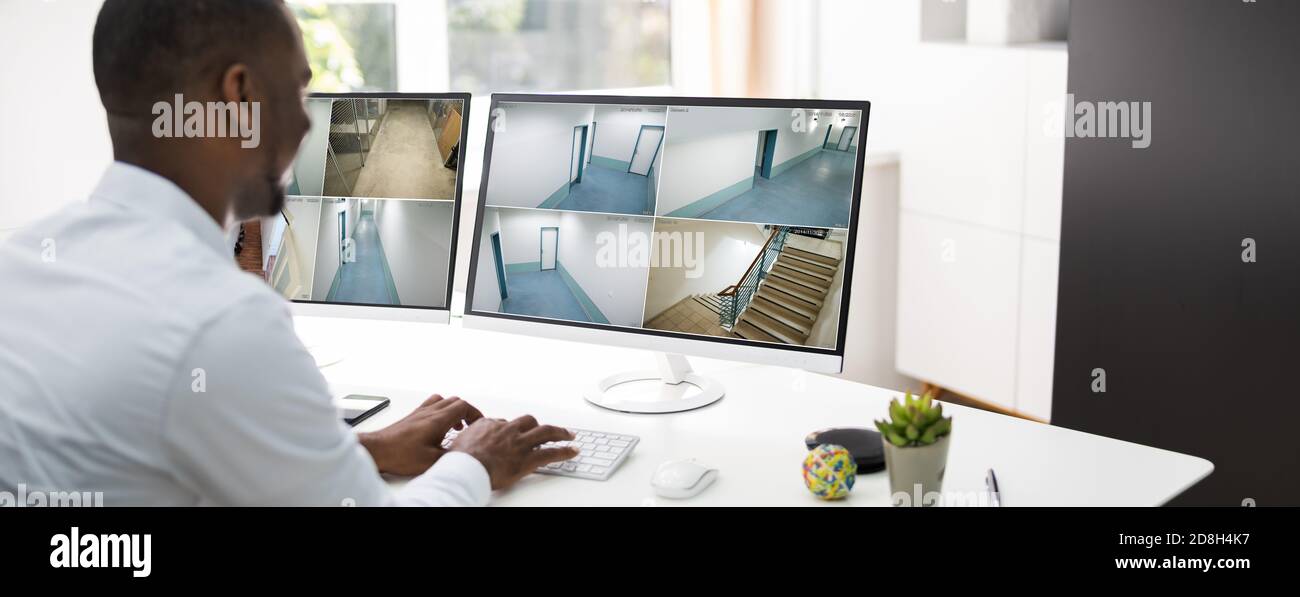 Security Guard Looking At CCTV Surveillance Video Footage Stock Photo ...