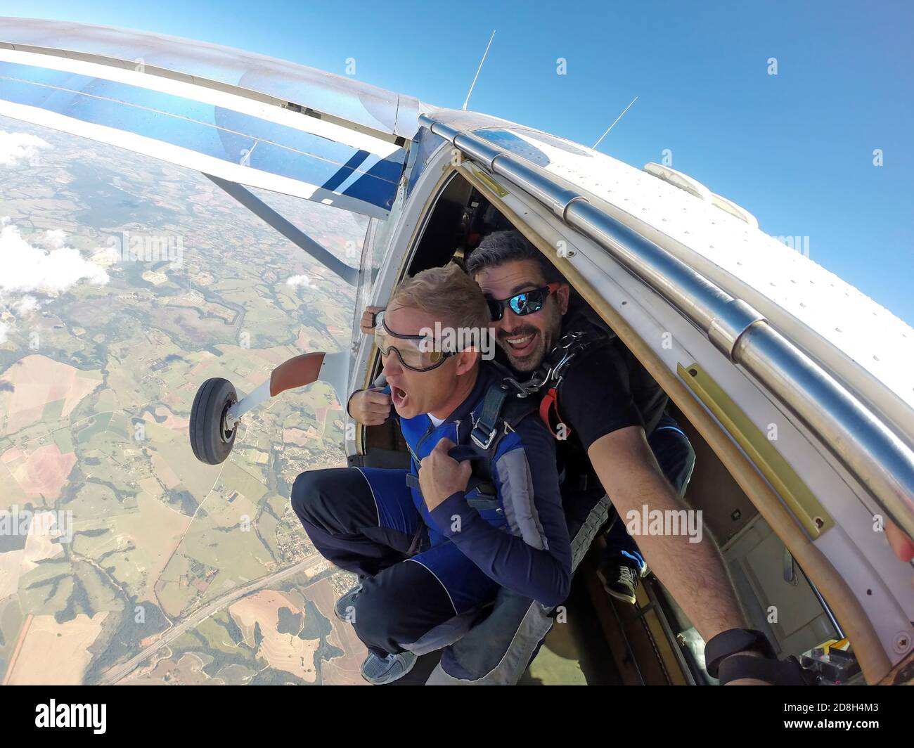 Skydiving. Happy Instructor and student screaming in aircraft door ...