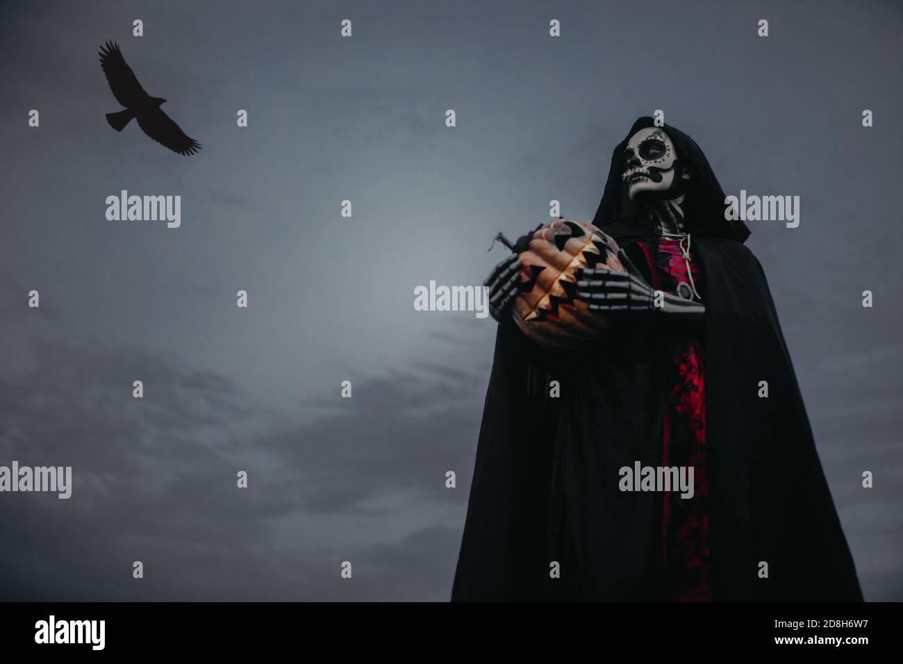 Young woman stands in Halloween costume of death with painted skeleton ...