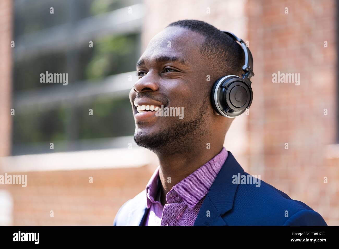 African American Man Listening Music On Wireless Headphones Outside ...