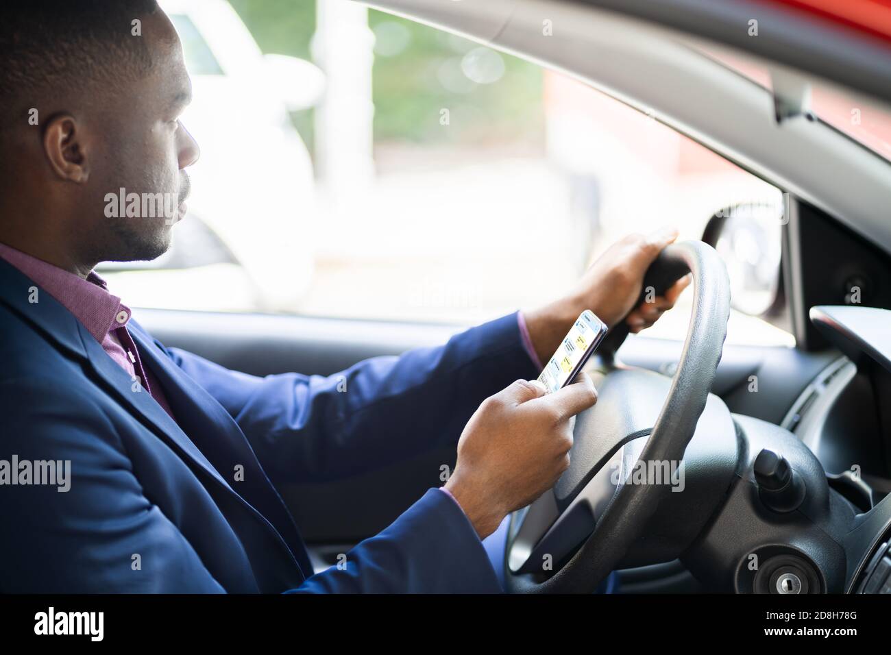Distracted African Man Texting On Mobile Phone While Driving Stock ...