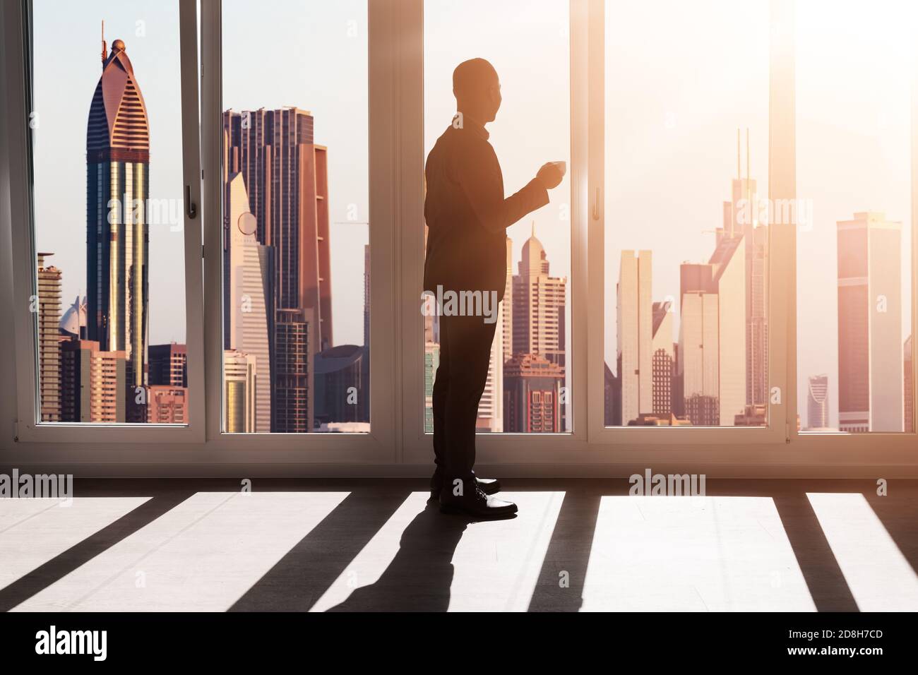African Businessman Viewing City Downtown Through Window Stock Photo ...