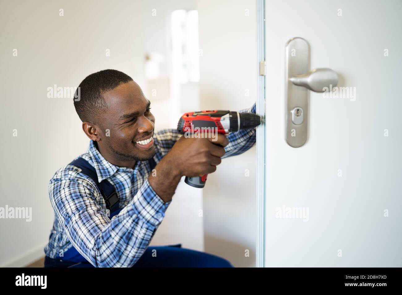 African Locksmith Man Changing And Fixing Door Lock Stock Photo - Alamy