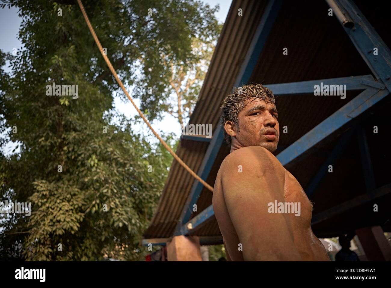 Delhi, India, May 2012. Kushti wrestler resting in the akhara in his ...