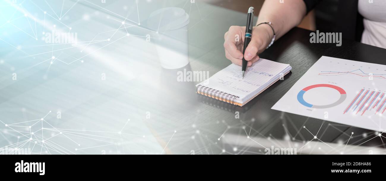 Businesswoman analysing marketing data and taking notes; panoramic ...