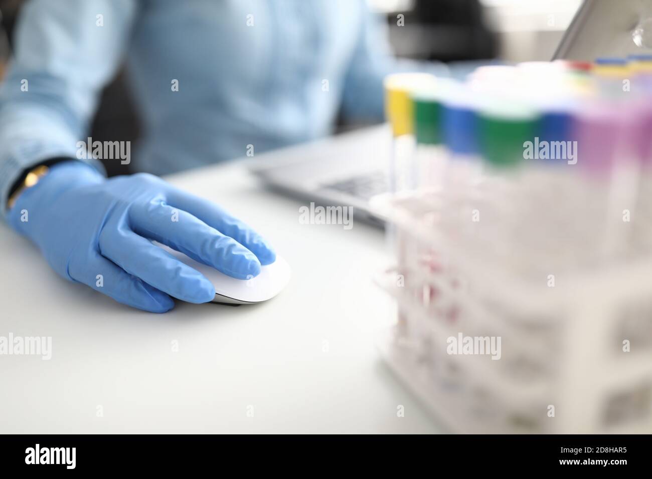Female hand in rubber glove holds computer mouse in chemical laboratory ...