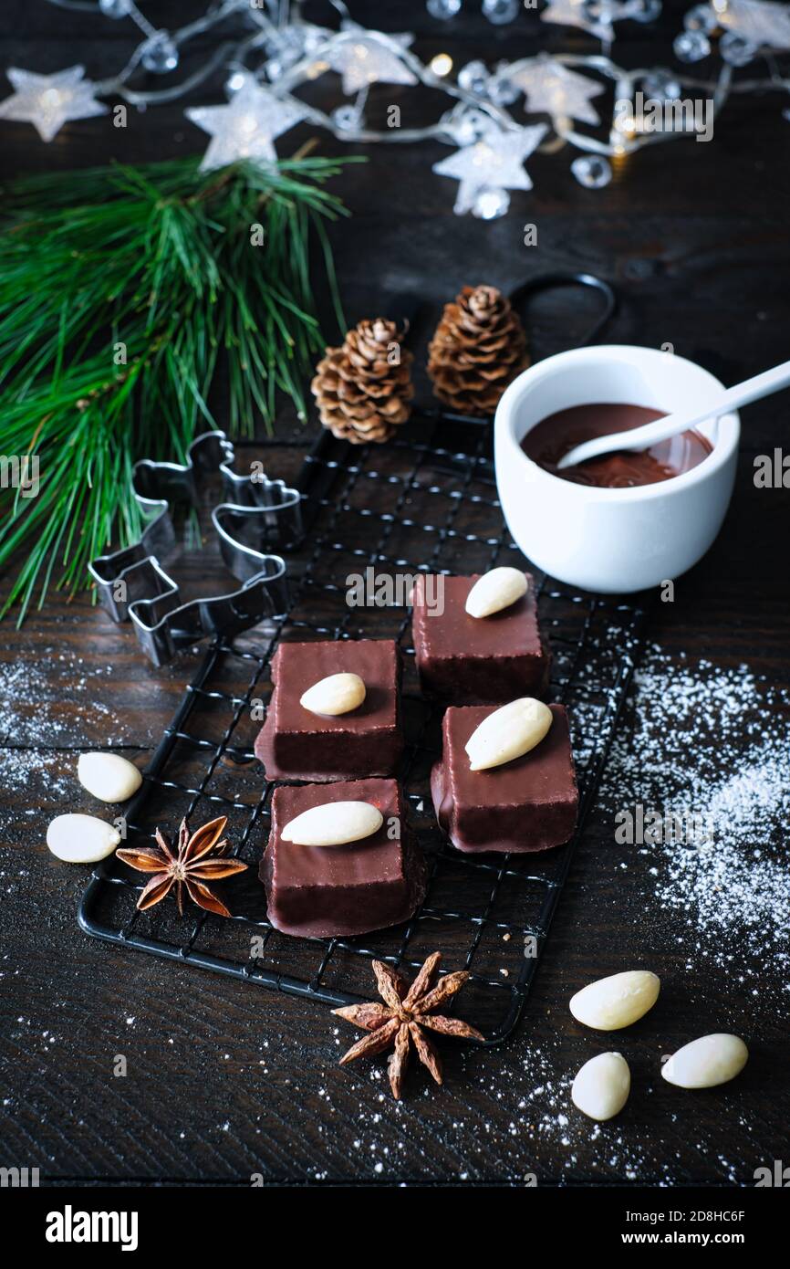 Marzipancubes with chocolate icing on a black cooling grid, decorated ...