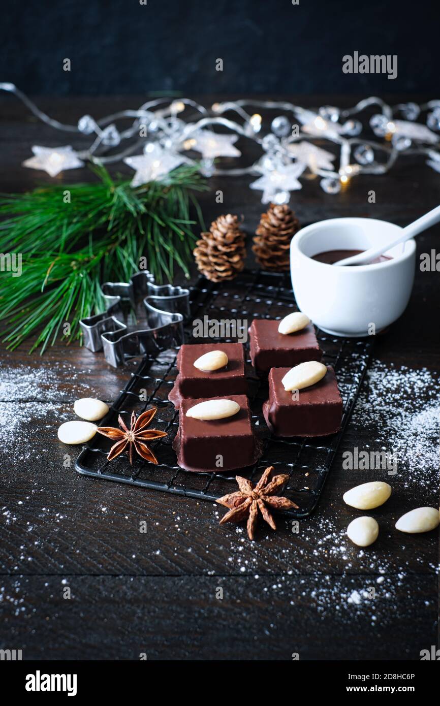 Marzipancubes with chocolate icing on a black cooling grid, decorated ...