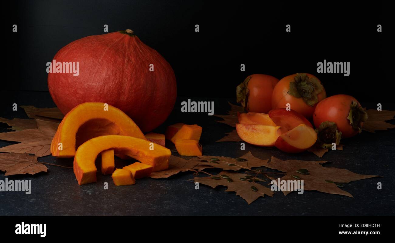 Autumnal vegetables and fruit: Pumpkin, kaki, sliced, whole, fresh and ...