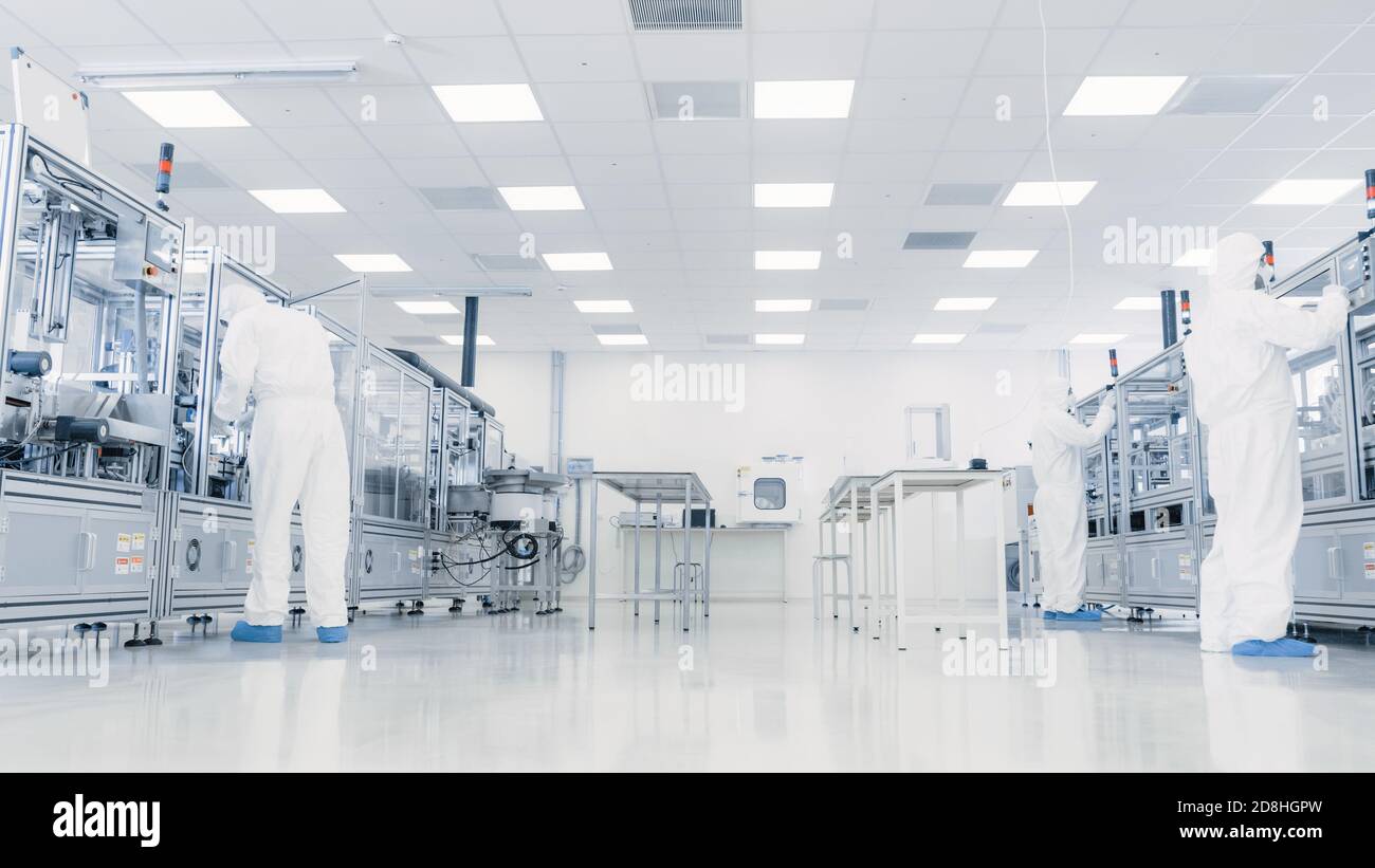 Team of Research Scientists in Sterile Suits Working with Computers ...