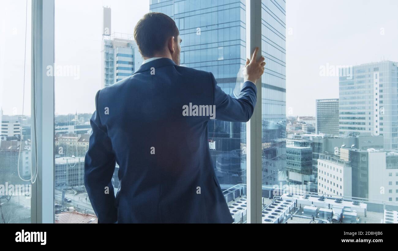 Confident Businessman in a Suit Looking out of the Window Thoughtfully ...