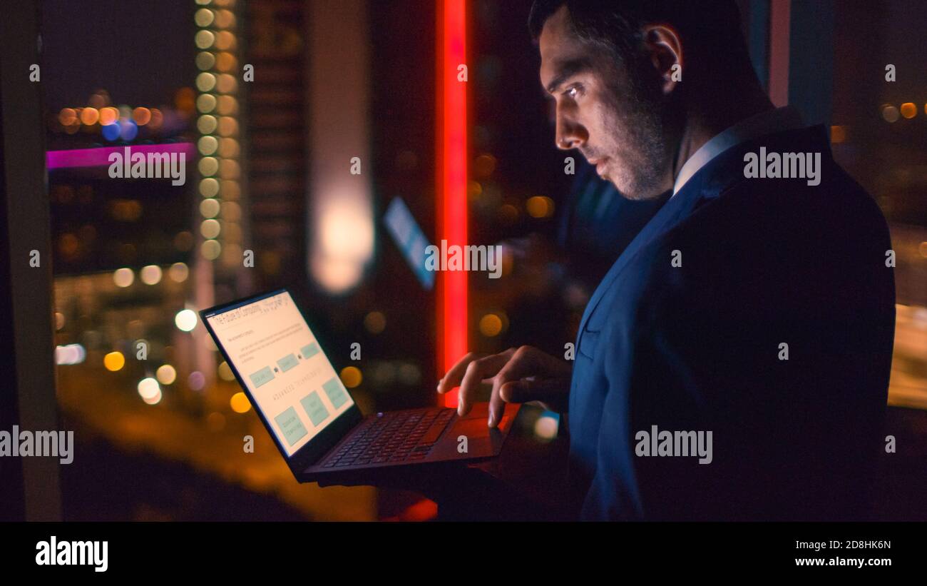 Late at Night in the Office Successful Businessman Holds Laptop while ...