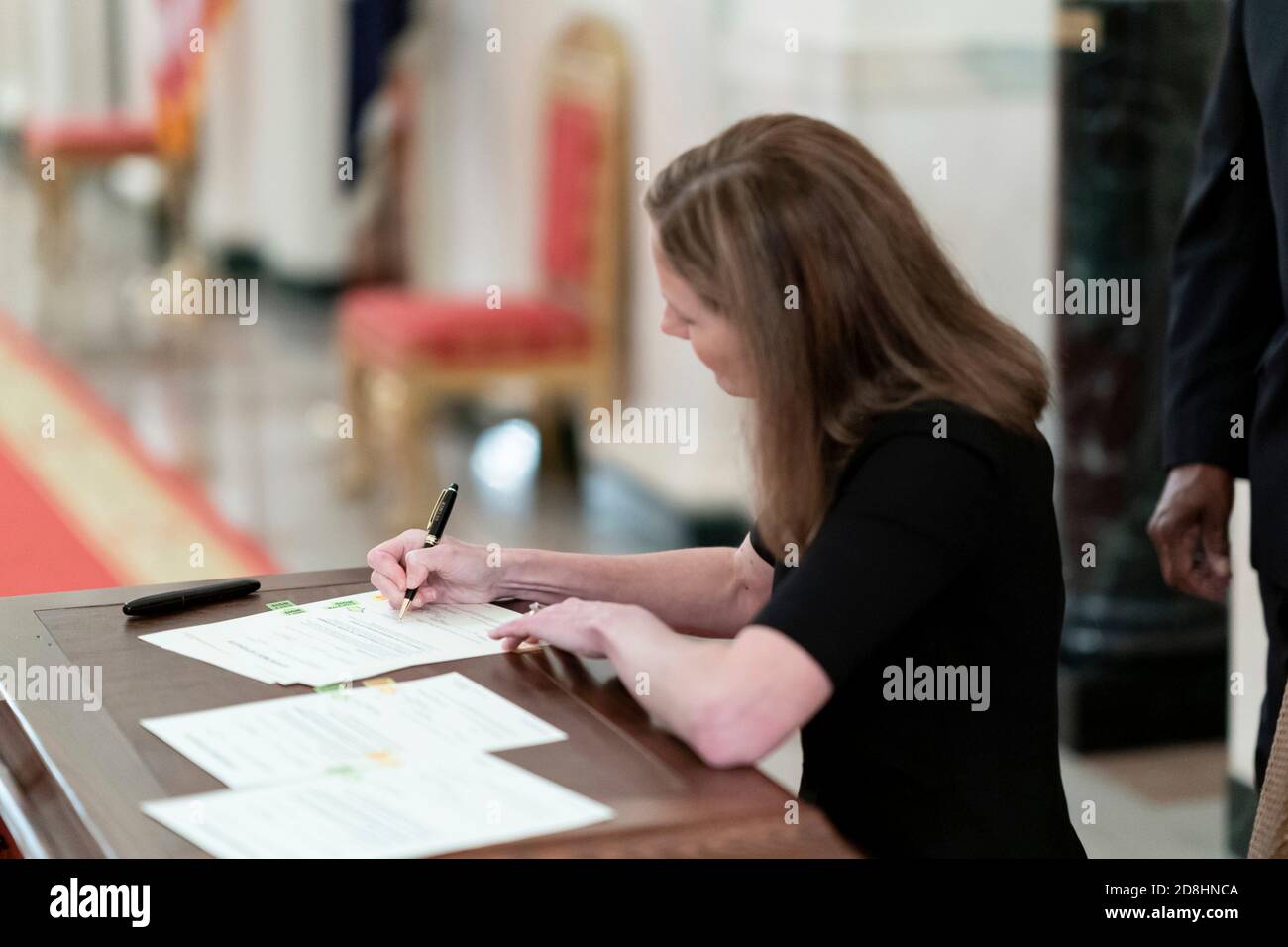 Judge Amy Coney Barrett signs the oath certificate during a ceremony in ...