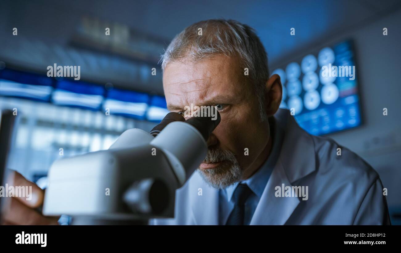 Senior Medical Research Scientist Looking under the Microscope in the ...