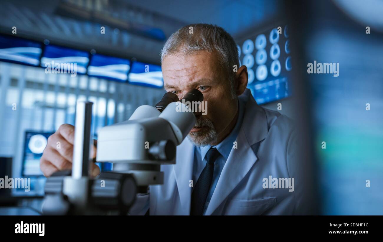 Senior Medical Research Scientist Looking under the Microscope in the ...