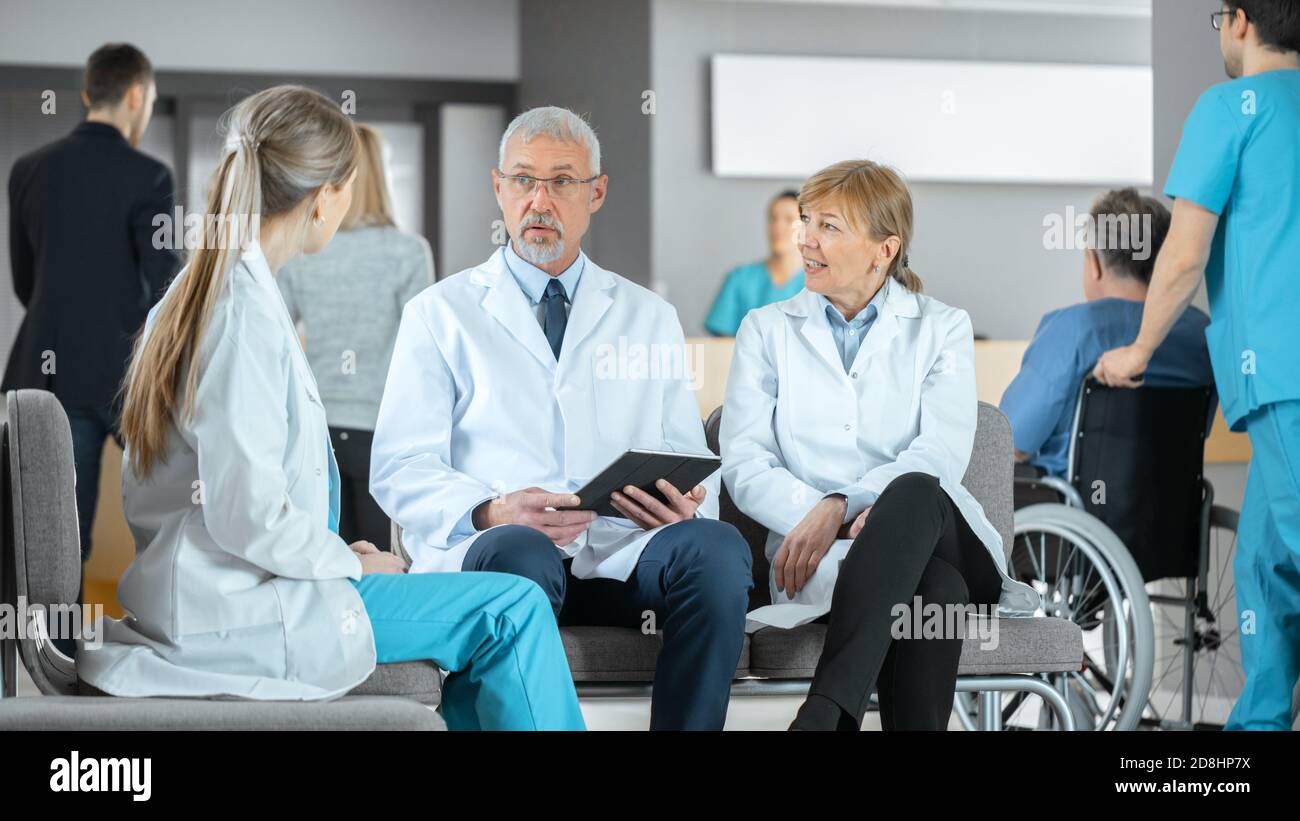 In the Lobby of the Hospital Three Professional Doctor Have Discussion ...
