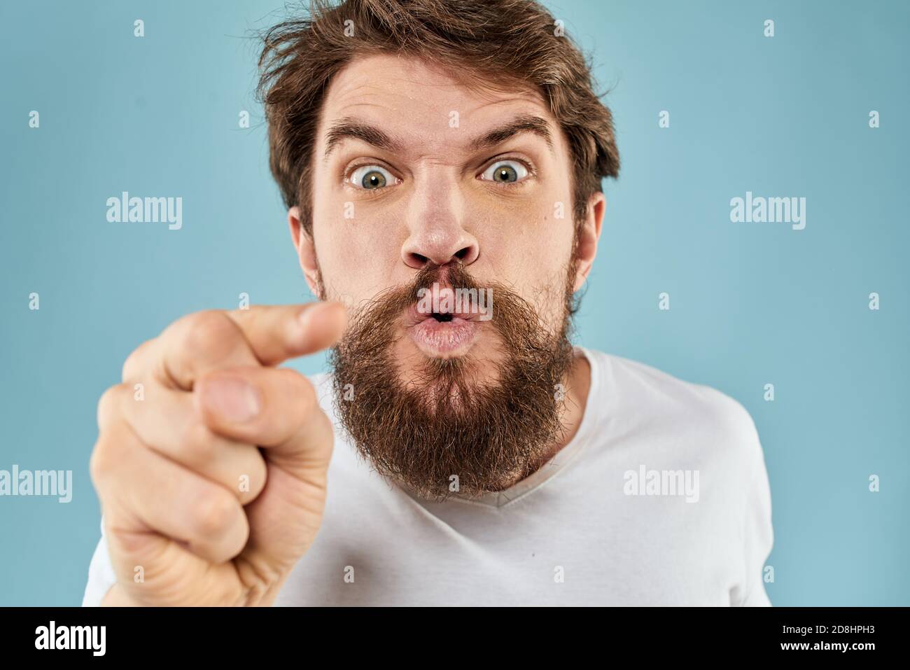 Bearded man in white T-shirt emotions gestures with hands displeased ...
