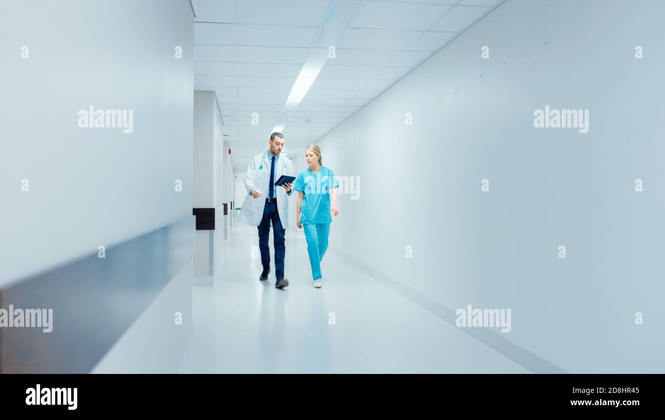Surgeon and Female Doctor Walk Through Hospital Hallway in a Hurry ...