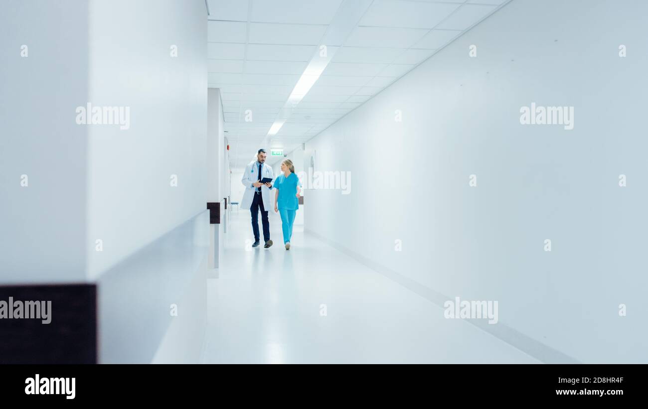 Surgeon and Female Doctor Walk Through Hospital Hallway in a Hurry ...