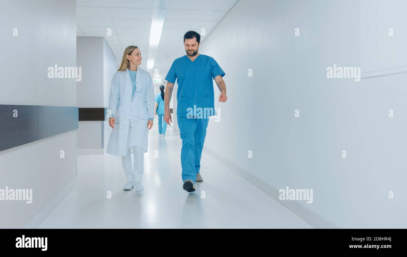 Surgeon and Female Doctor Walk Through Hospital Hallway in a Hurry ...