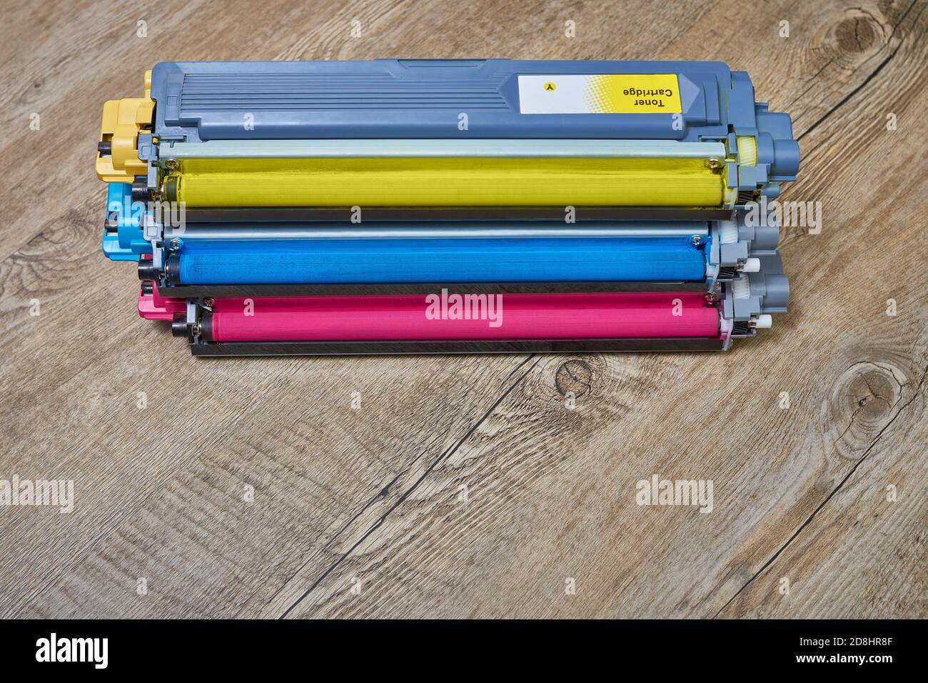 Yellow, cyan and magenta toner cartridges stacked horizontally on ...