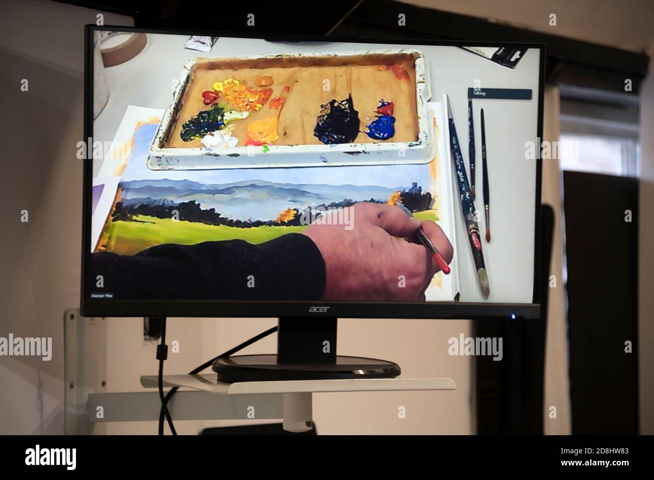 Paintbrush in hand of an art tutor demonstrating a painting technique ...