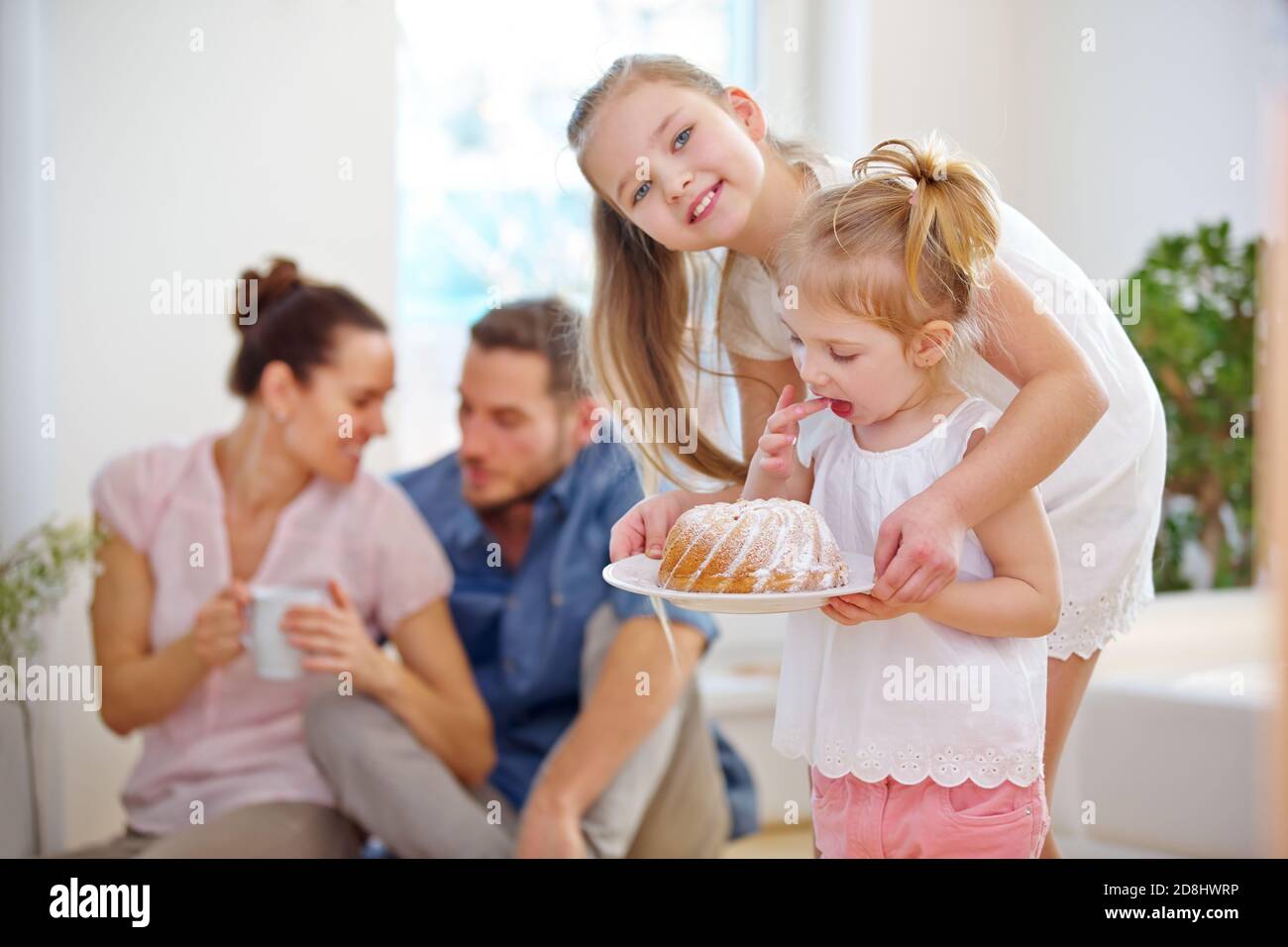 Children carry cakes to family at home in the living room Stock Photo ...