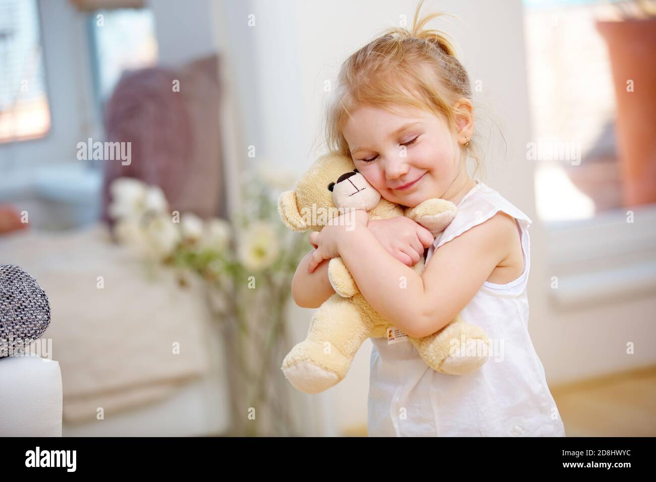 Child cuddles with her soft cuddly toy at home Stock Photo - Alamy