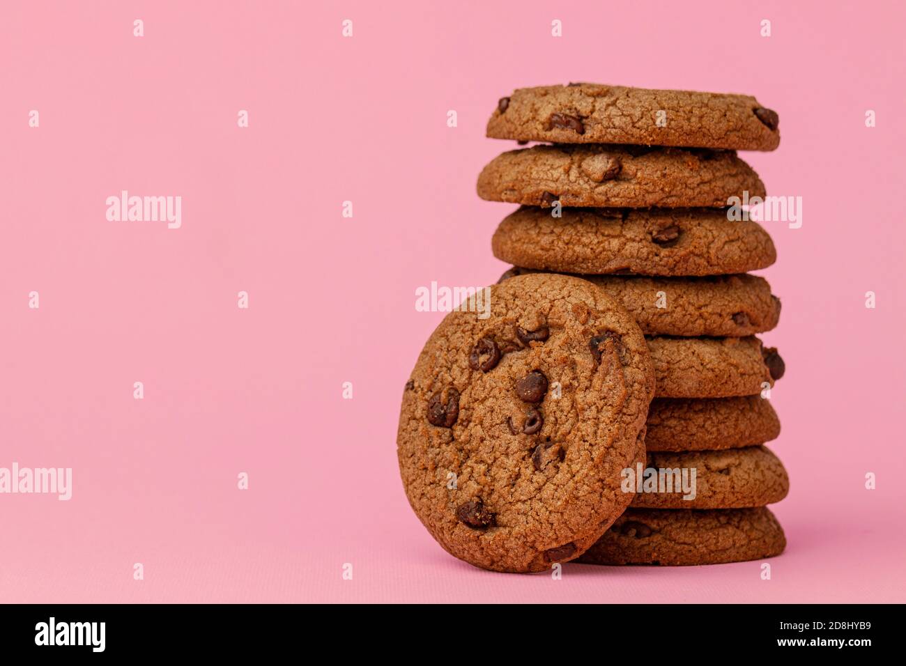 Stacked chocolate chip cookies against pink background Stock Photo - Alamy