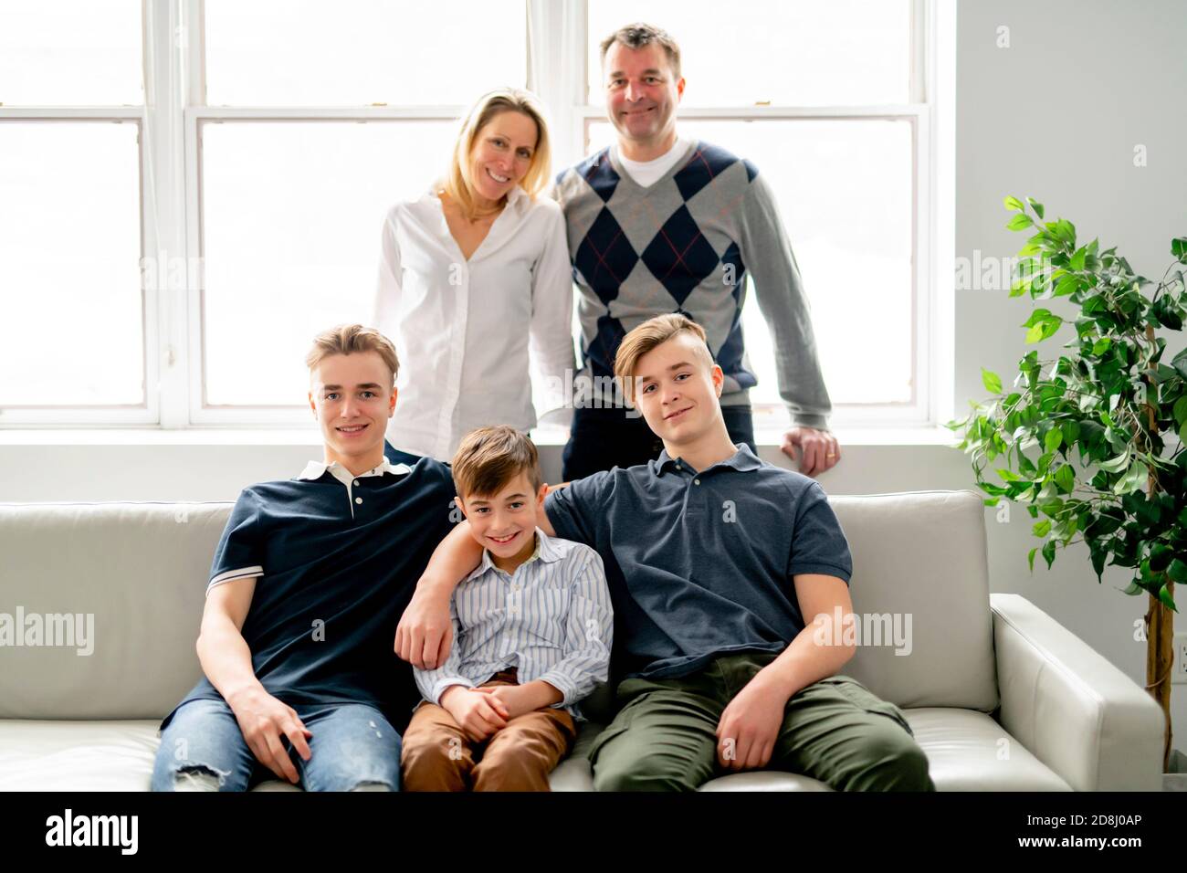Beautiful happy family sit on sofa at home Stock Photo - Alamy