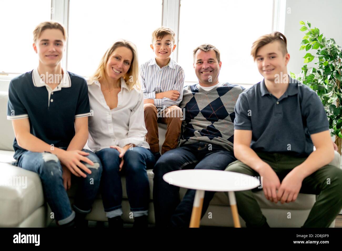 Beautiful happy family sit on sofa at home Stock Photo - Alamy