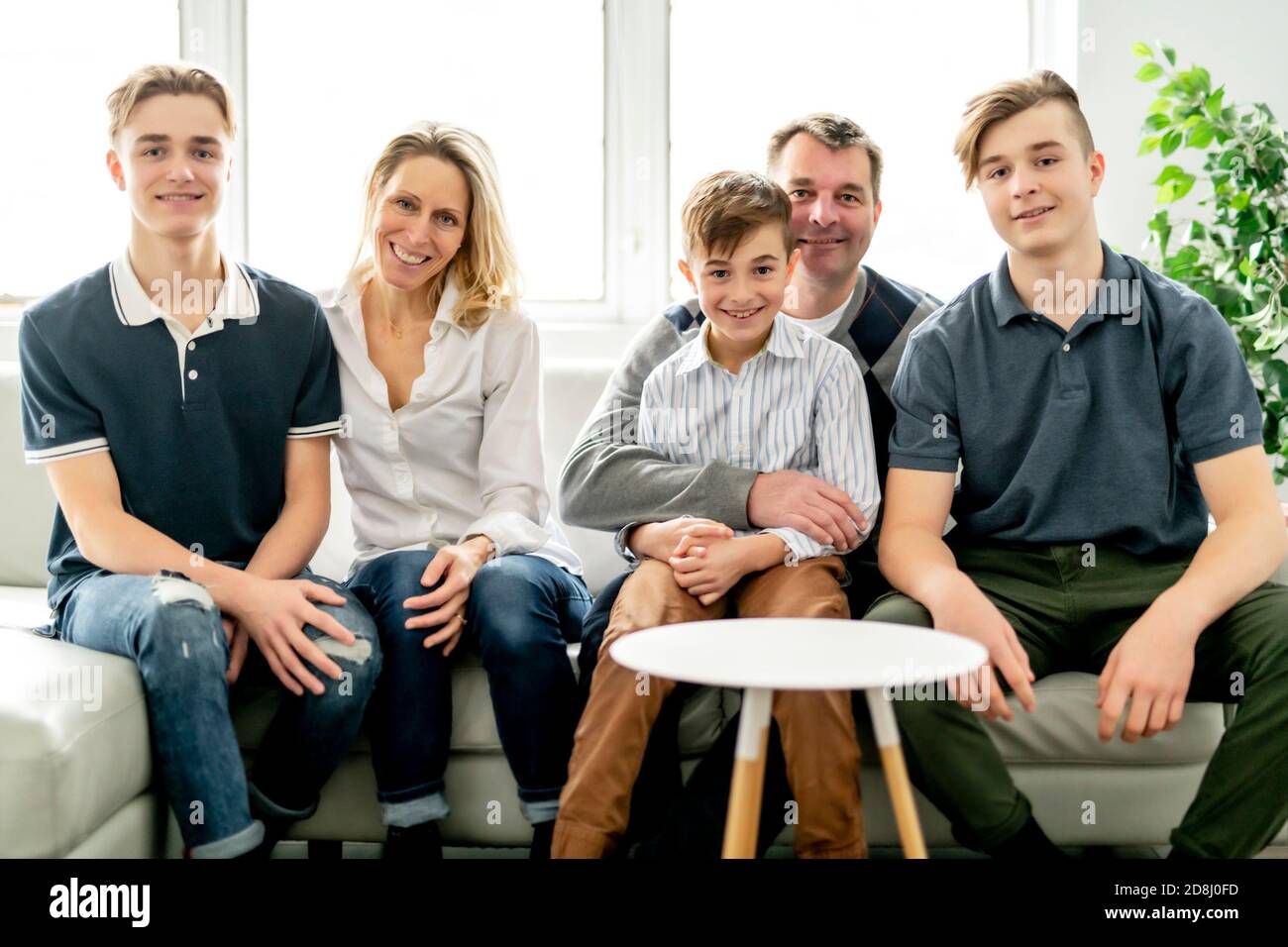 Beautiful happy family sit on sofa at home Stock Photo - Alamy
