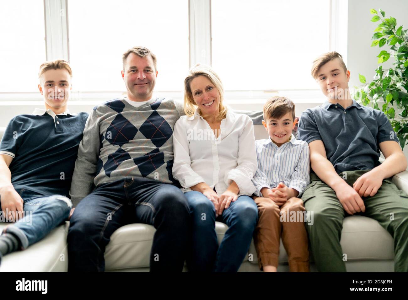 Beautiful happy family sit on sofa at home Stock Photo - Alamy