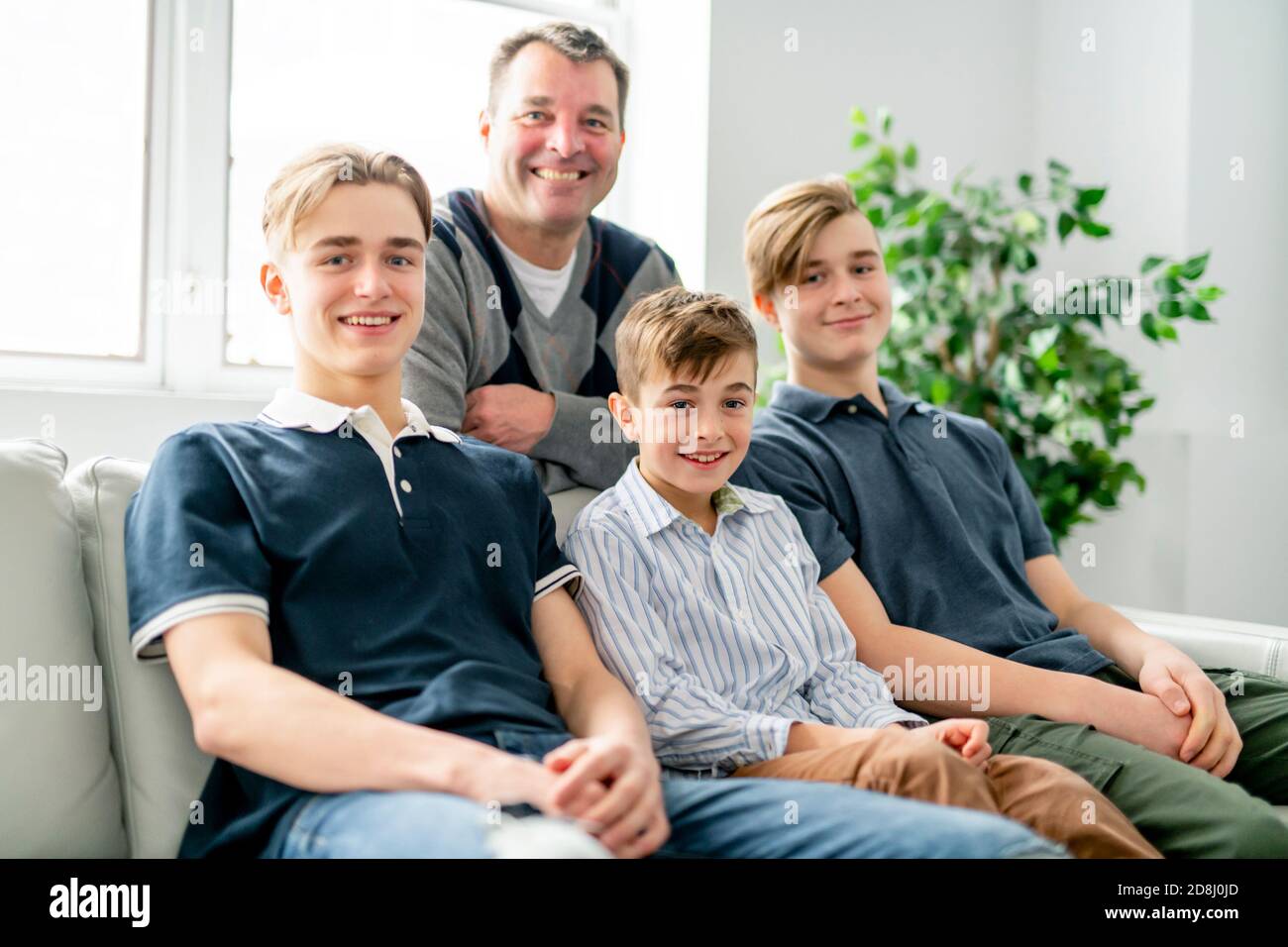 Beautiful happy family sit on sofa at home Stock Photo - Alamy