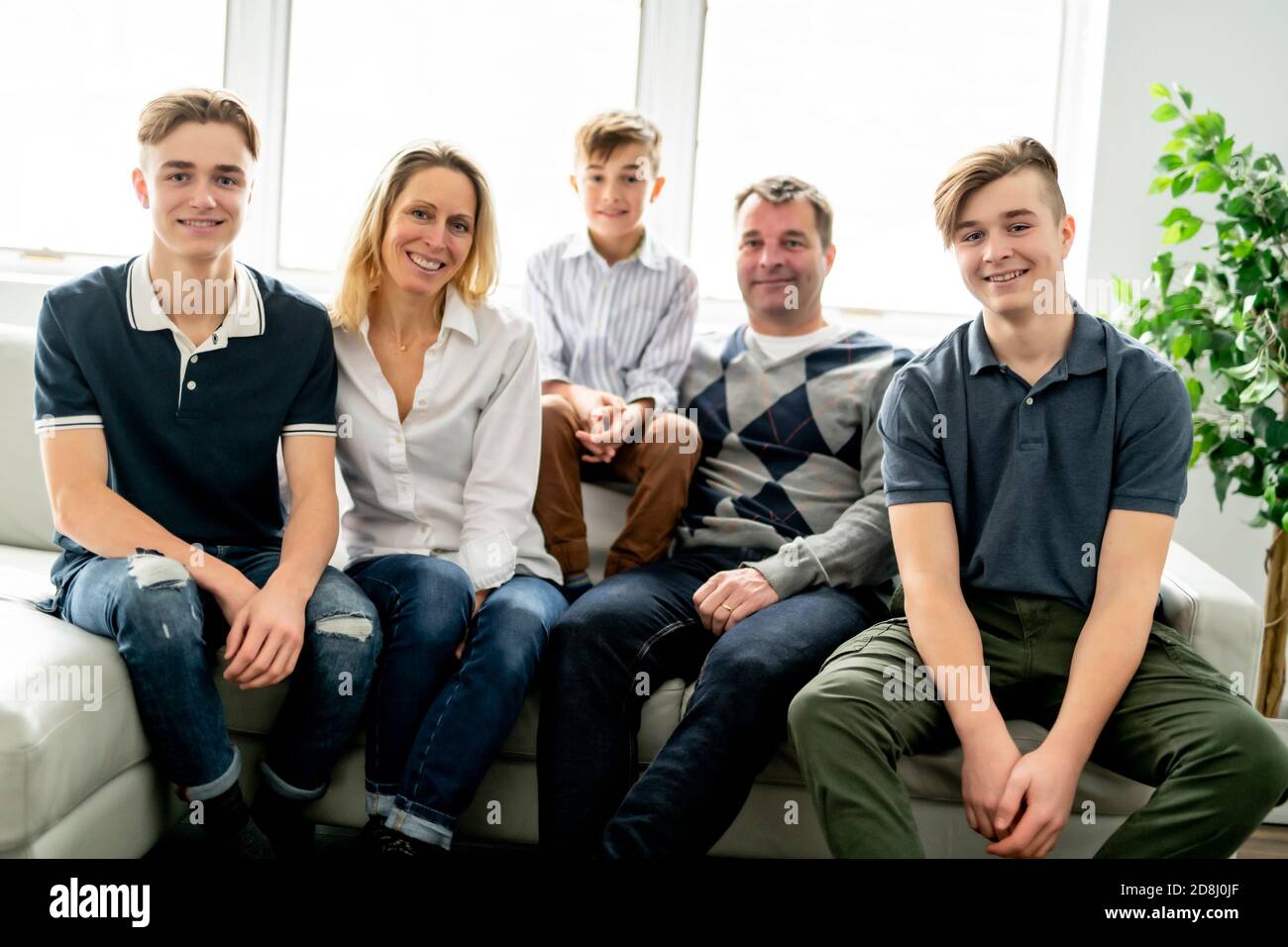 Beautiful happy family sit on sofa at home Stock Photo - Alamy