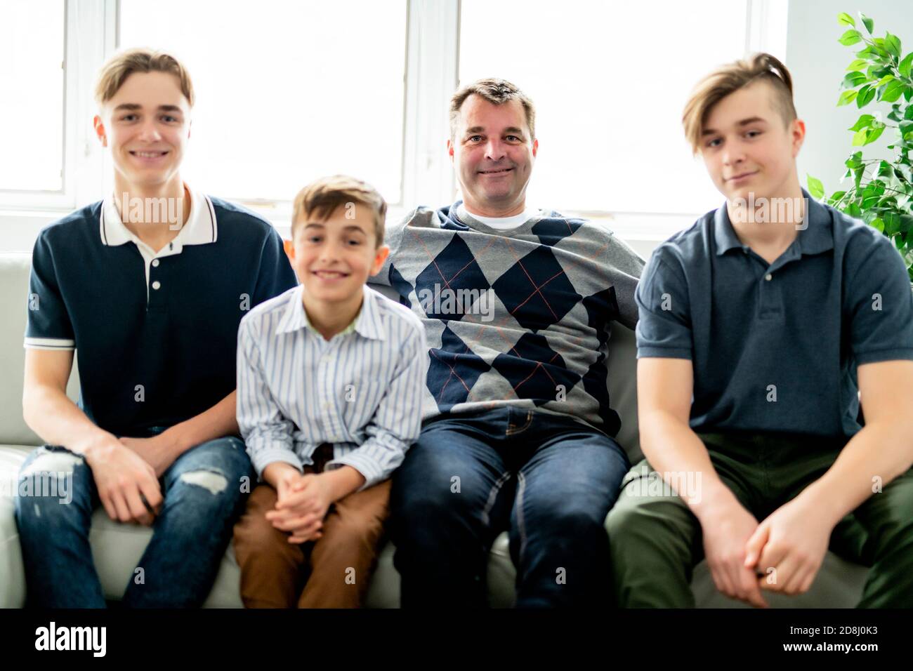 Beautiful happy family sit on sofa at home Stock Photo - Alamy