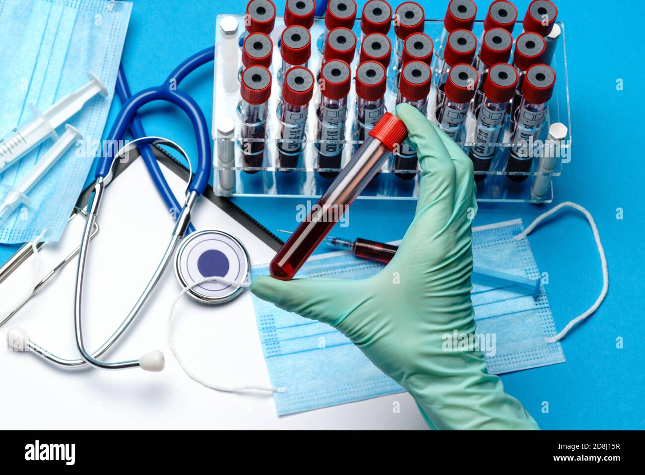 lab technician assistant or doctor holding a blood sample in test tube ...