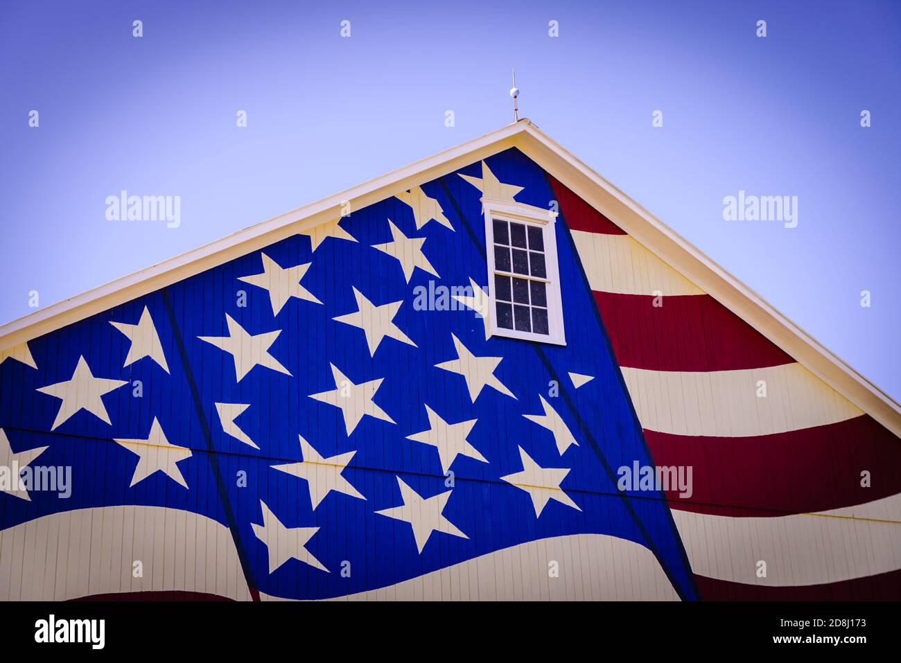The American flag (the stars and stripes) on a white barn in rural ...